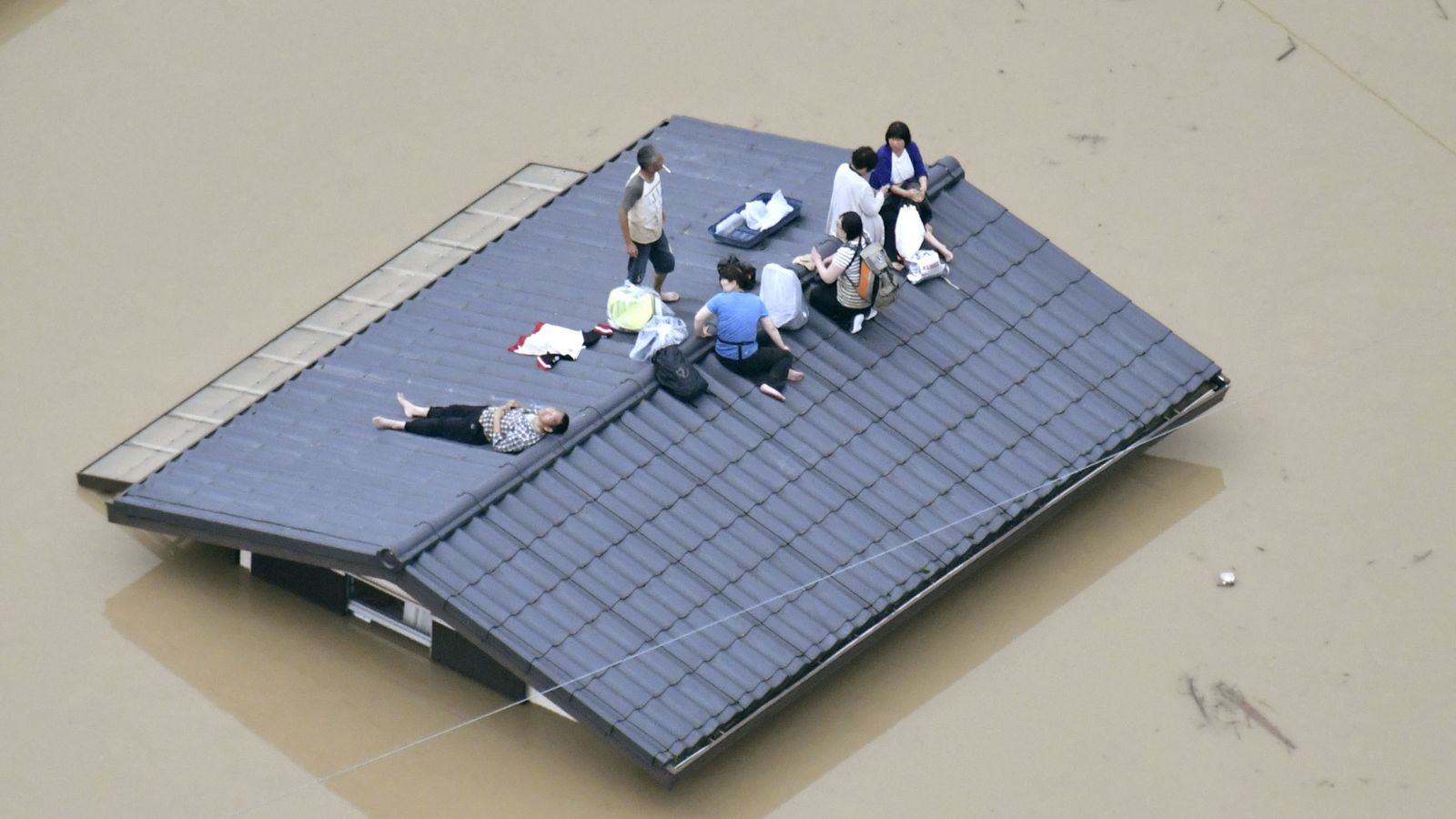 Japan's 'race against time' to save flood victims after dozens die ...
