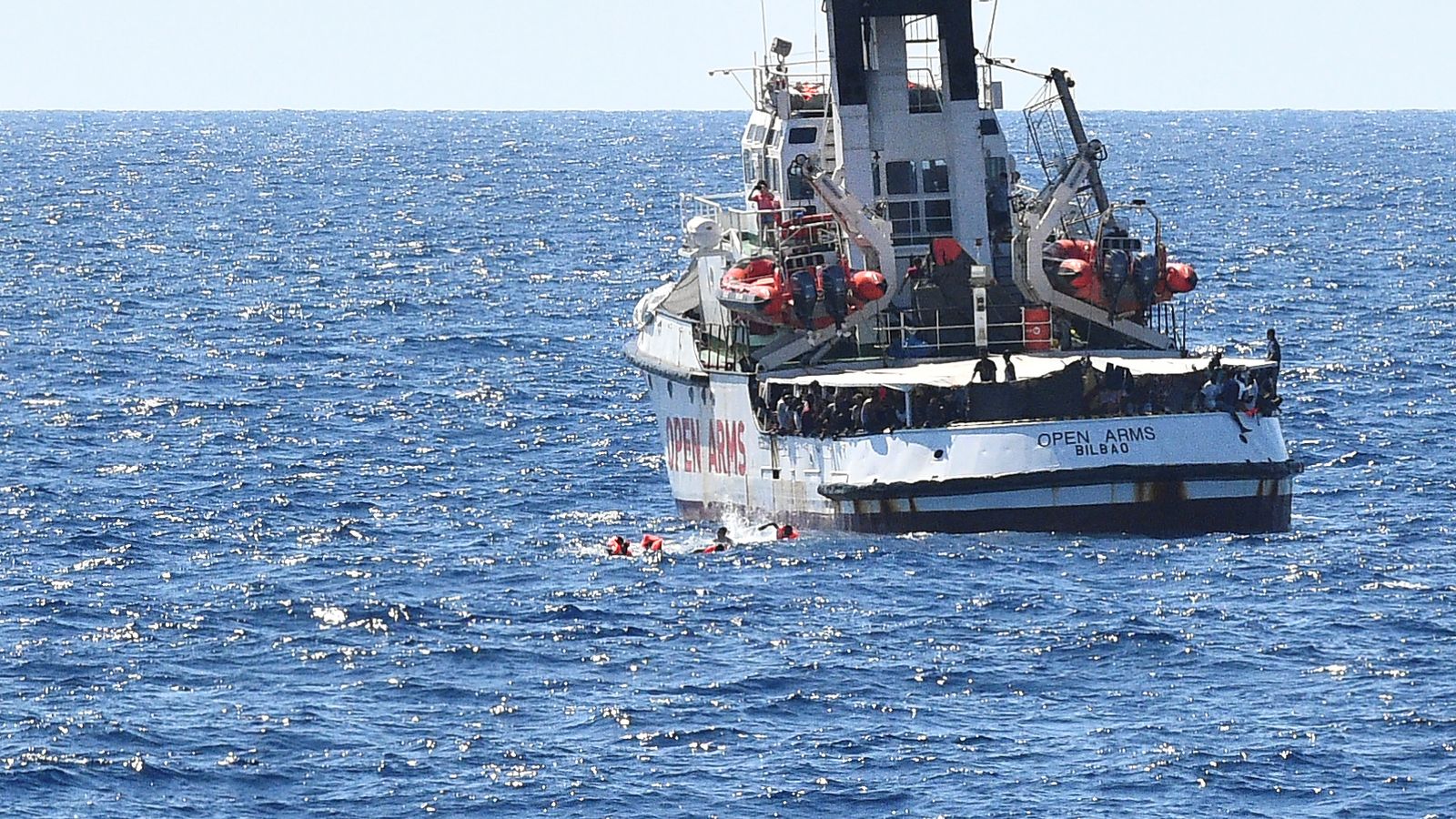 Migrants rescued after jumping into sea from humanitarian rescue ship ...