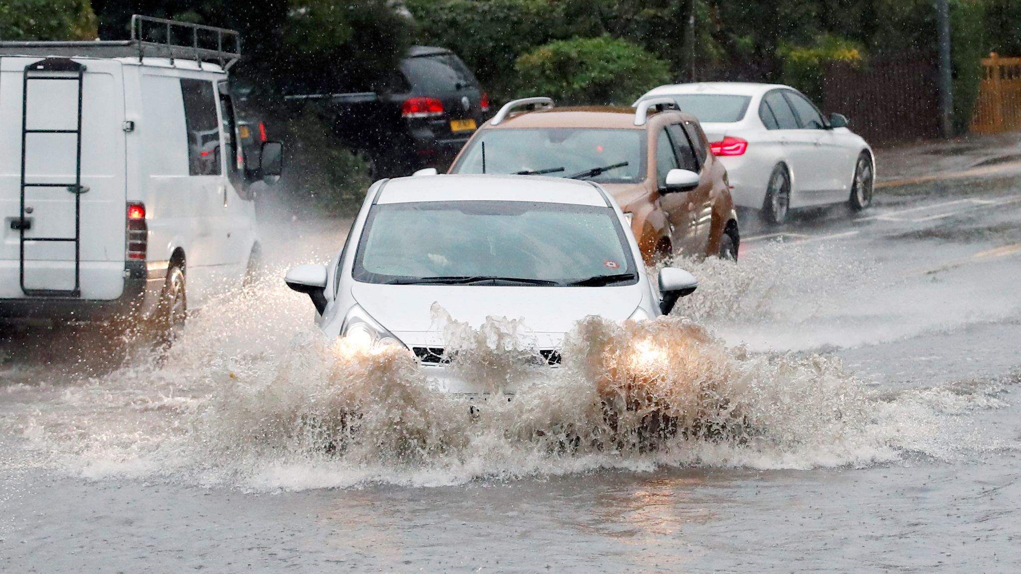 UK weather: Roads flooded and trains cancelled as heavy rain hits ...