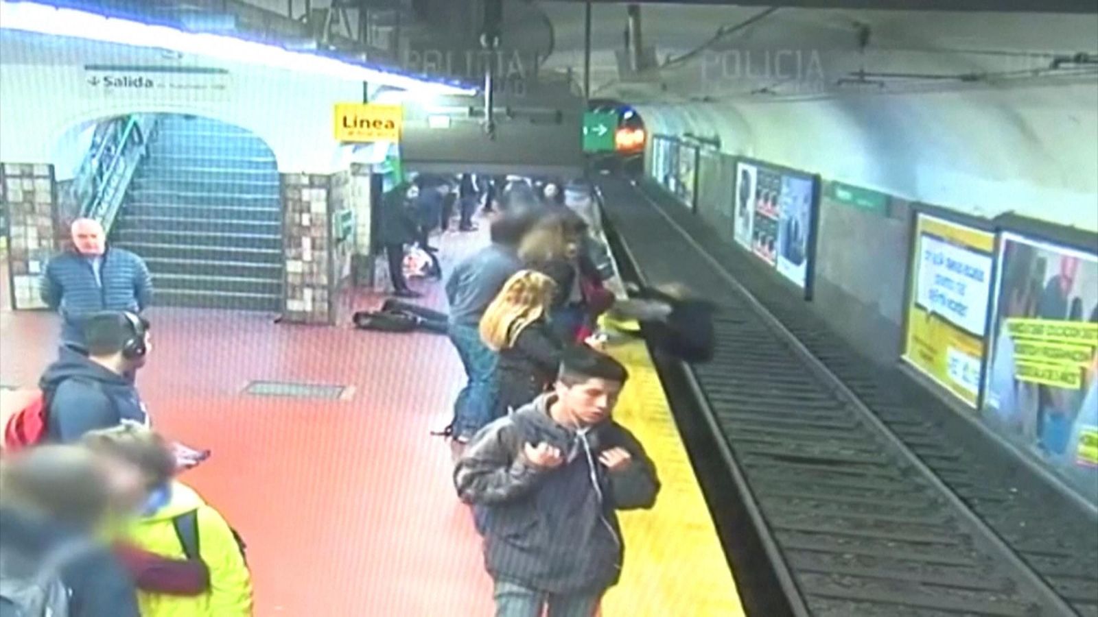 Moment crowd rescues woman who fell on track | World News | Sky News