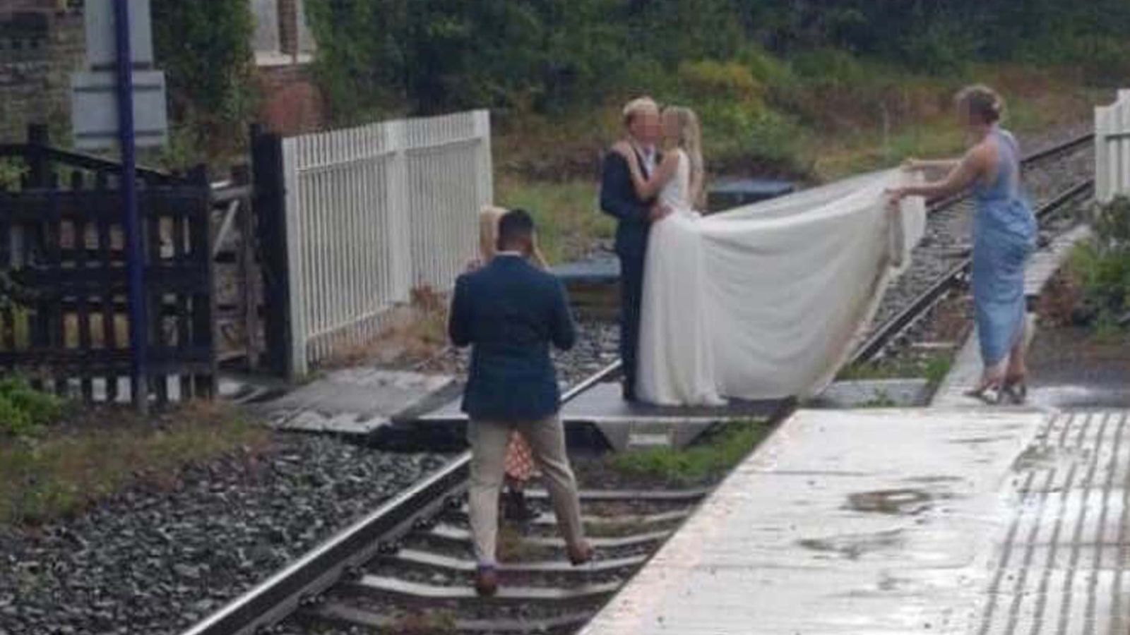Bride and groom posing for pictures on train track among 5,000 ...