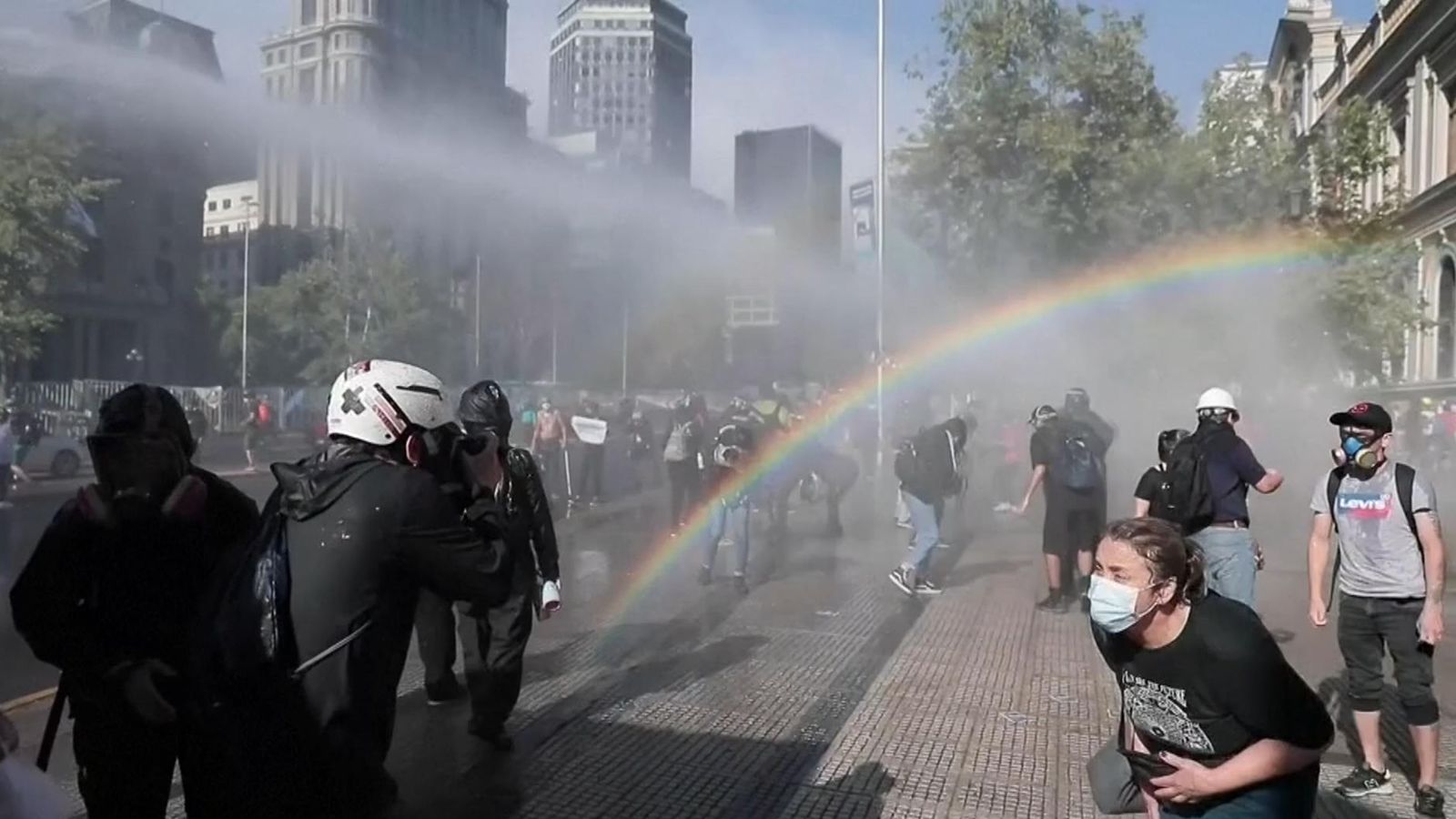 Santiago: Protesters face down water cannon and riot police in Chile ...