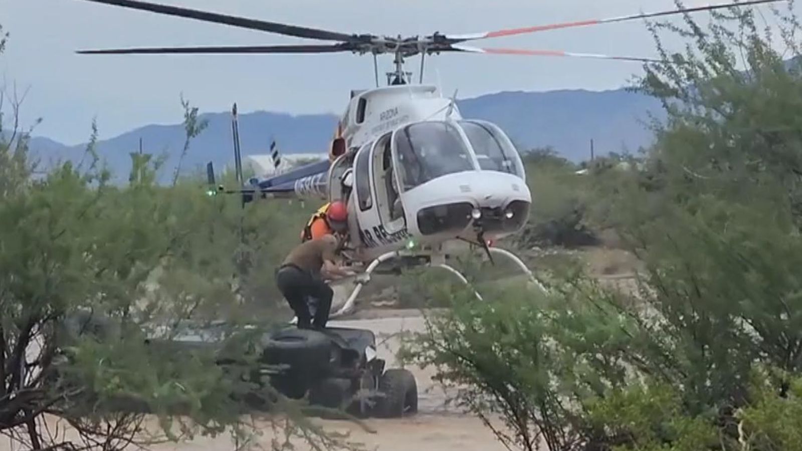 Arizona: Man rescued from top of his car after becoming stranded in ...