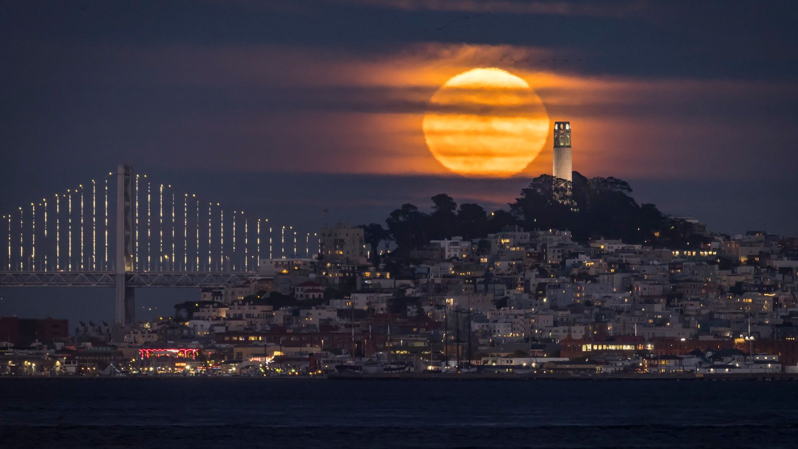 In pictures: Glowing supermoon delights stargazers across the UK and ...