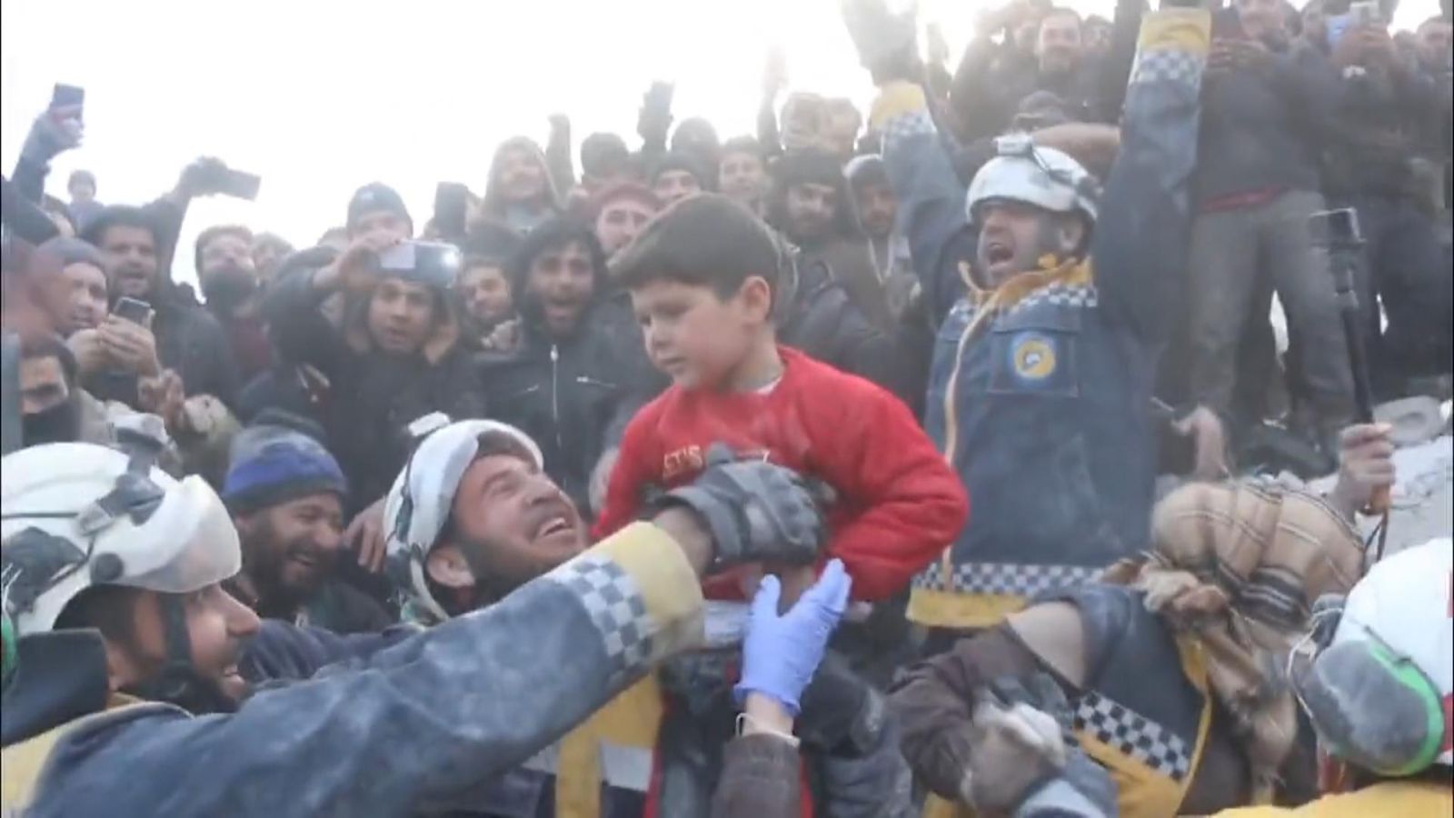 A crowd watching rescuers in Syria rejoices as children are pulled ...