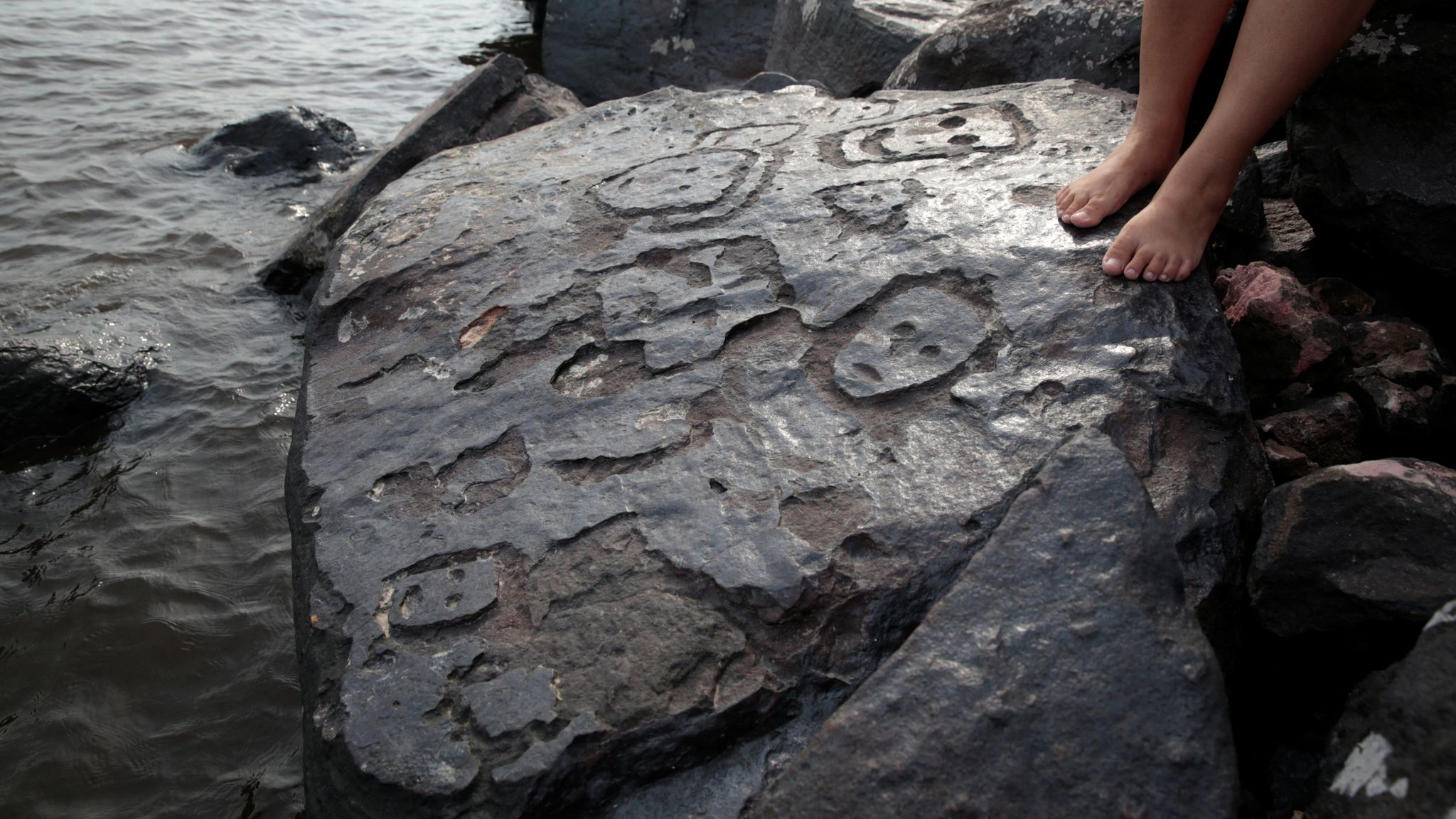 Ancient rock carvings of human faces revealed by Amazon River drought ...