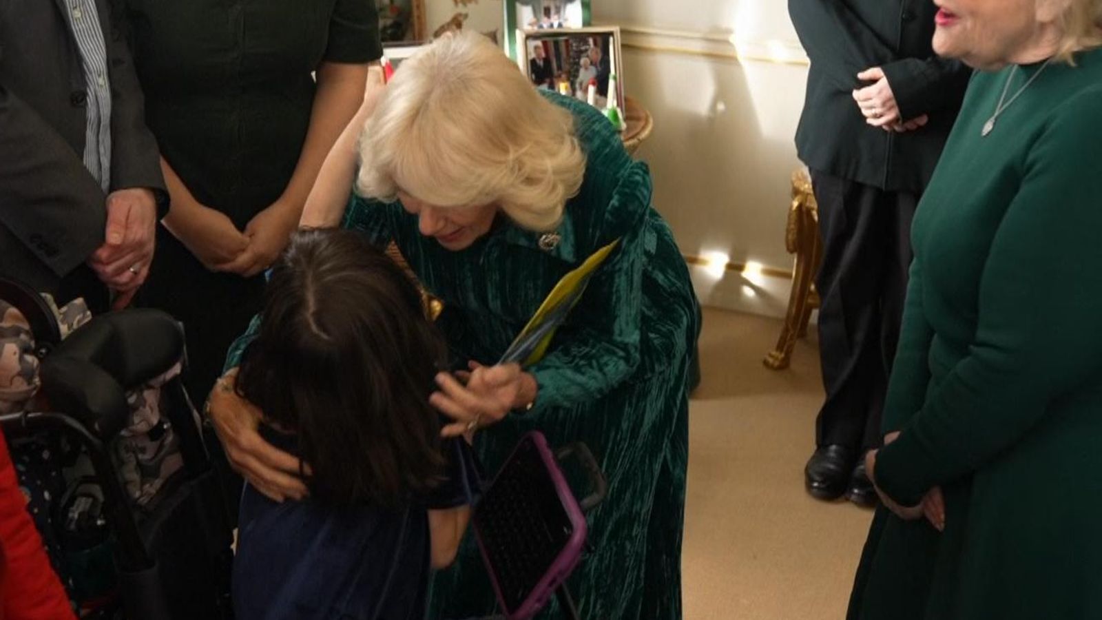 Girl surprises the Queen with a hug as children decorate Christmas tree ...