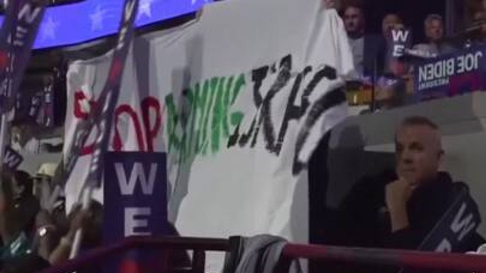 Pro-Palestine demonstrators hold up sign against Biden at Democratic ...