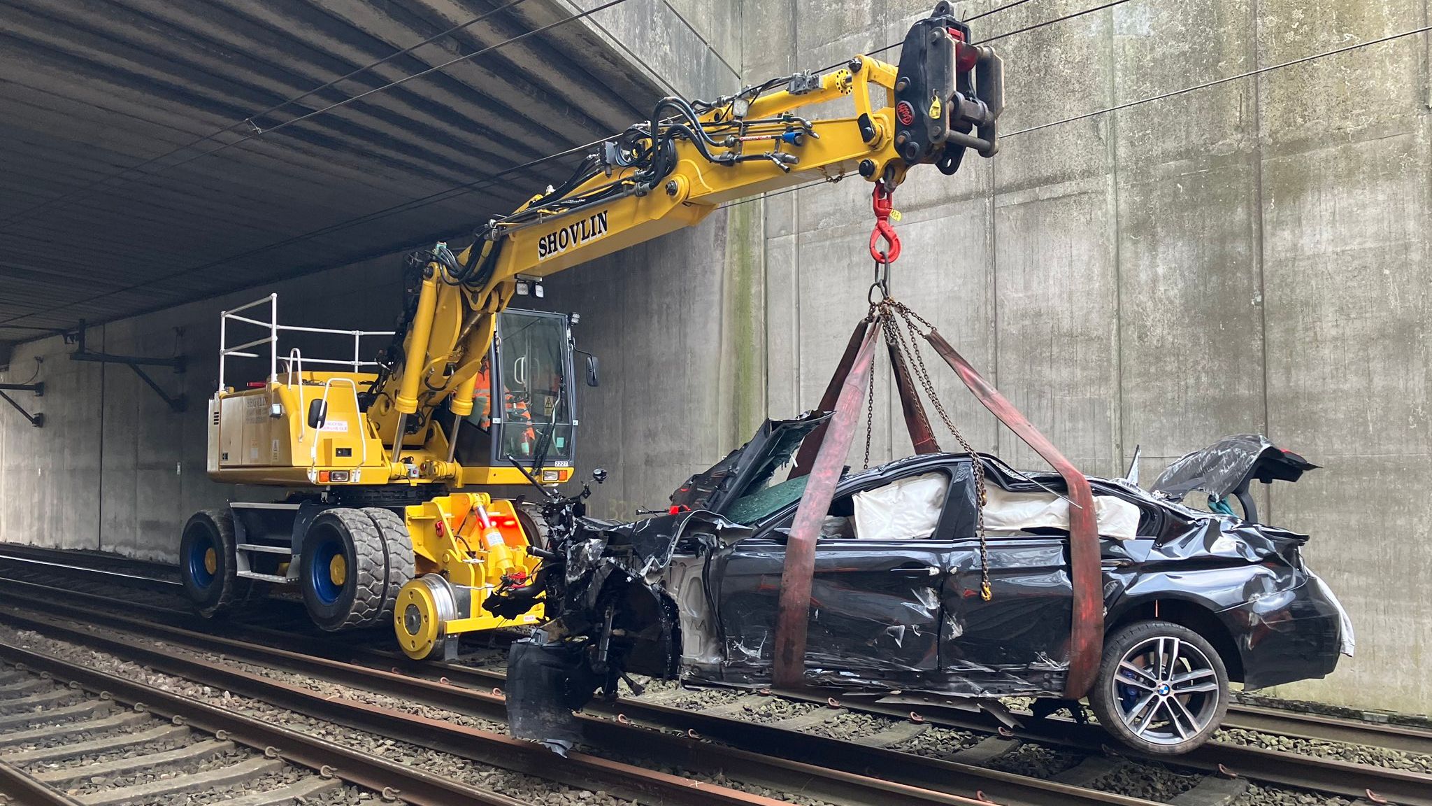 Car drives over bridge crashing onto rail line in Greater Manchester ...
