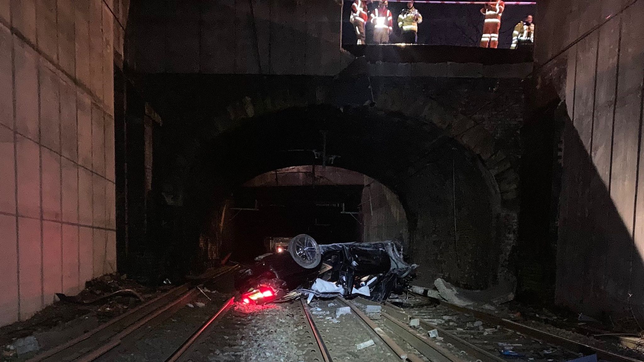 Car drives over bridge crashing onto rail line in Greater Manchester ...