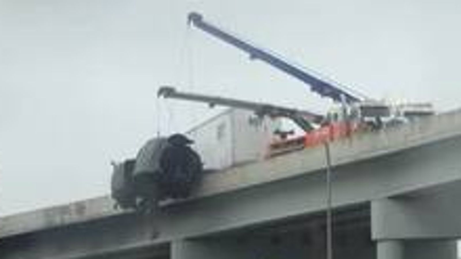 Driver lifted to safety after truck left hanging off side of bridge in ...